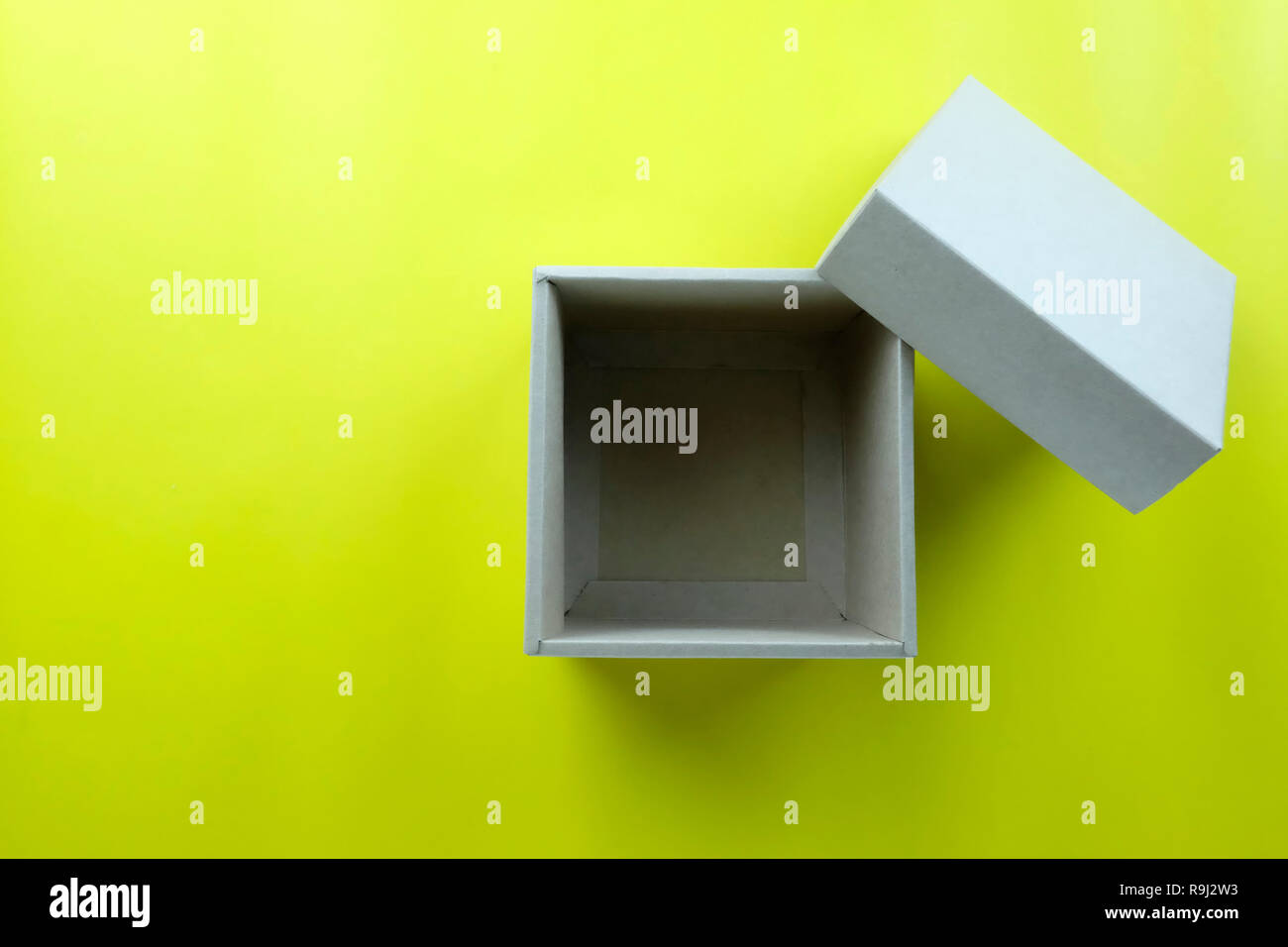 Empty brown paper box rests on a yellow paper floor and have copy space ...