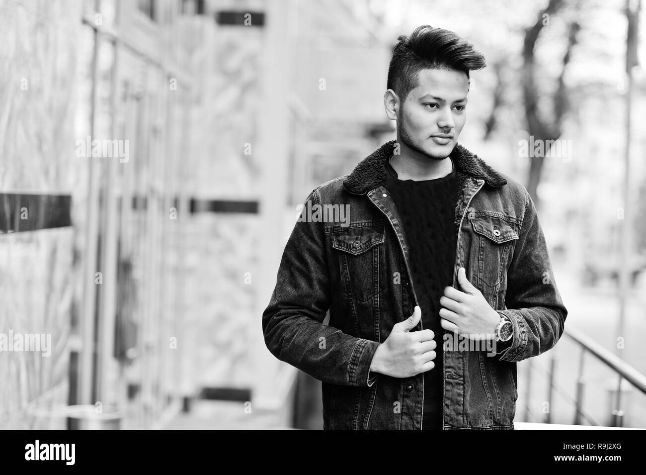 Handsome and fashionable indian man in black jeans jacket posed outdoor ...