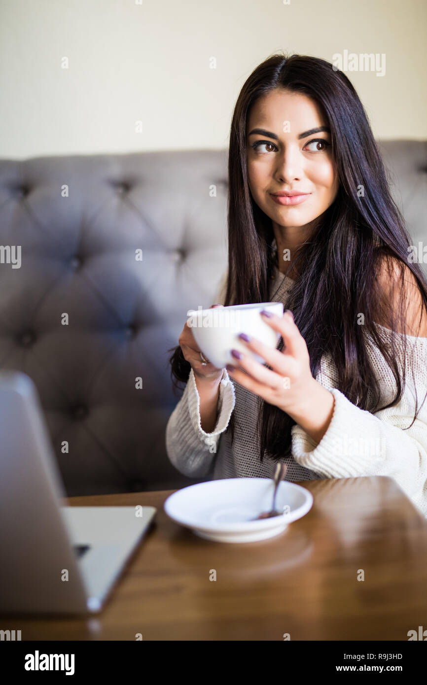 Young beautiful woman drinking coffee at cafe bar Stock Photo - Alamy