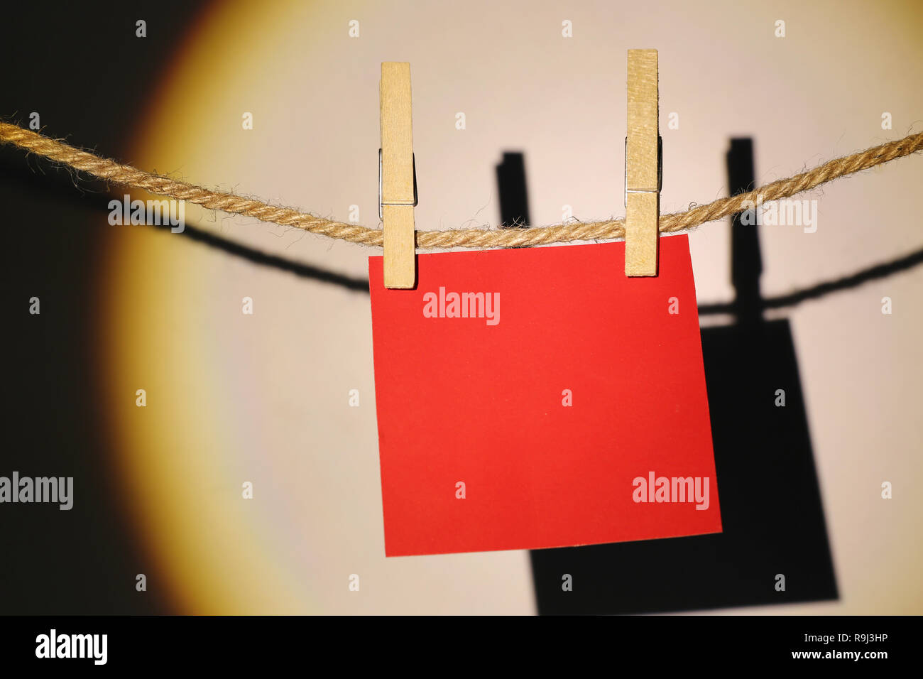 Red note paper hanging on rope on white wall and have clipping paths ...