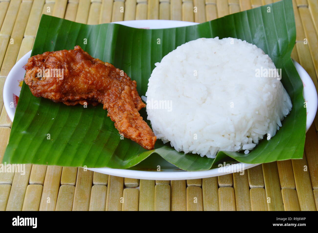 deep fried chicken wing and plain rice on banana leaf Stock Photo - Alamy