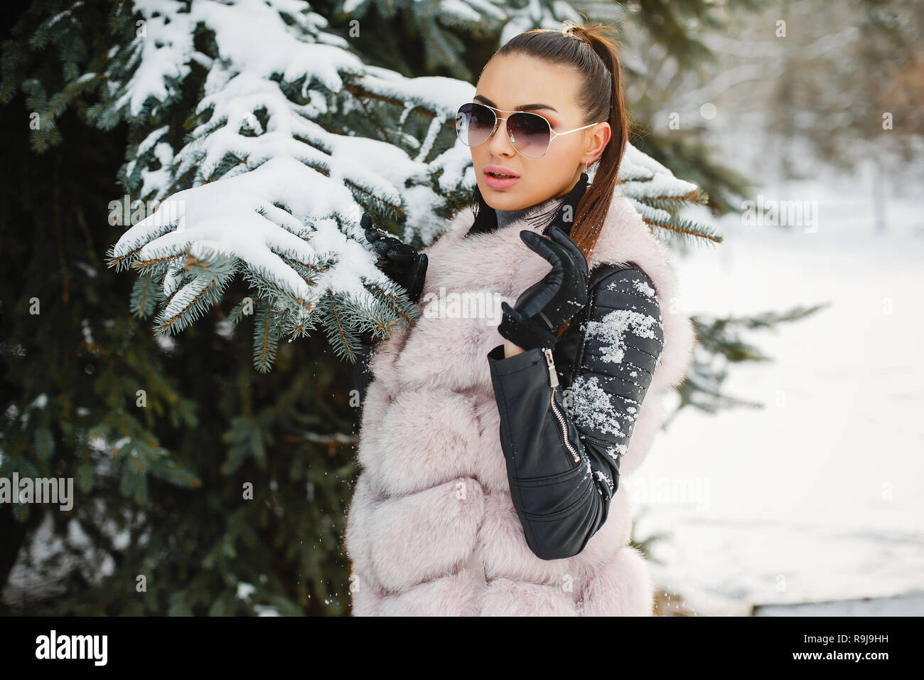 elegant and magnificent girl in stylish fur coat walking in a winter ...