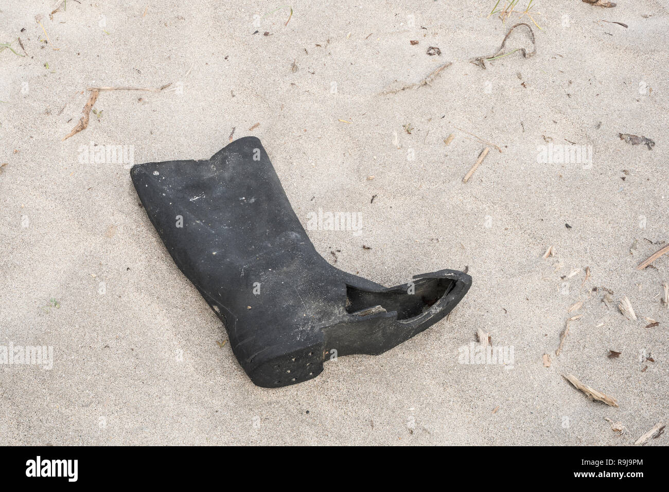 Old rubber boot washed up on shore & polluting shoreline. For plastic ...