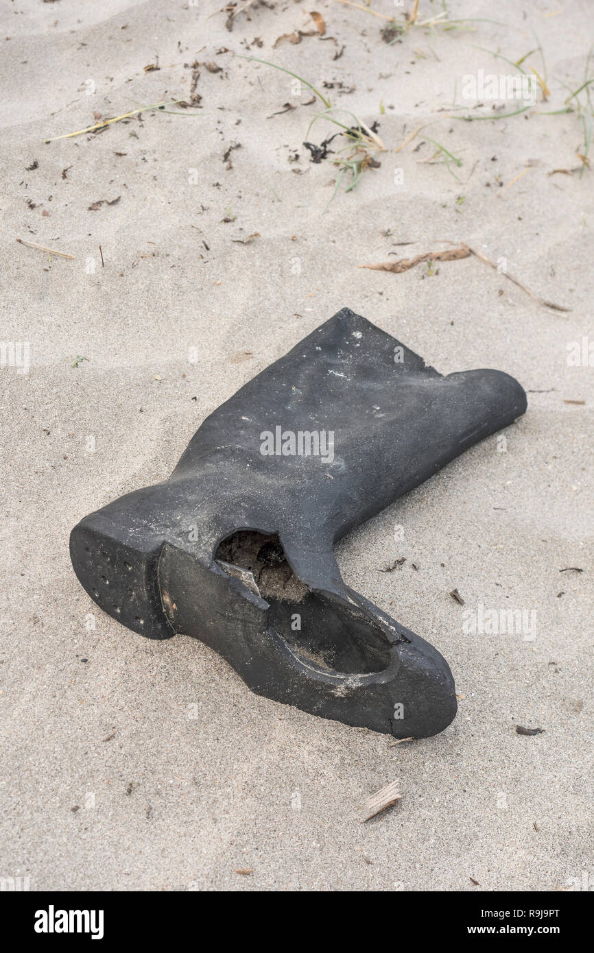 Old rubber boot washed up on shore & polluting shoreline. For plastic ...