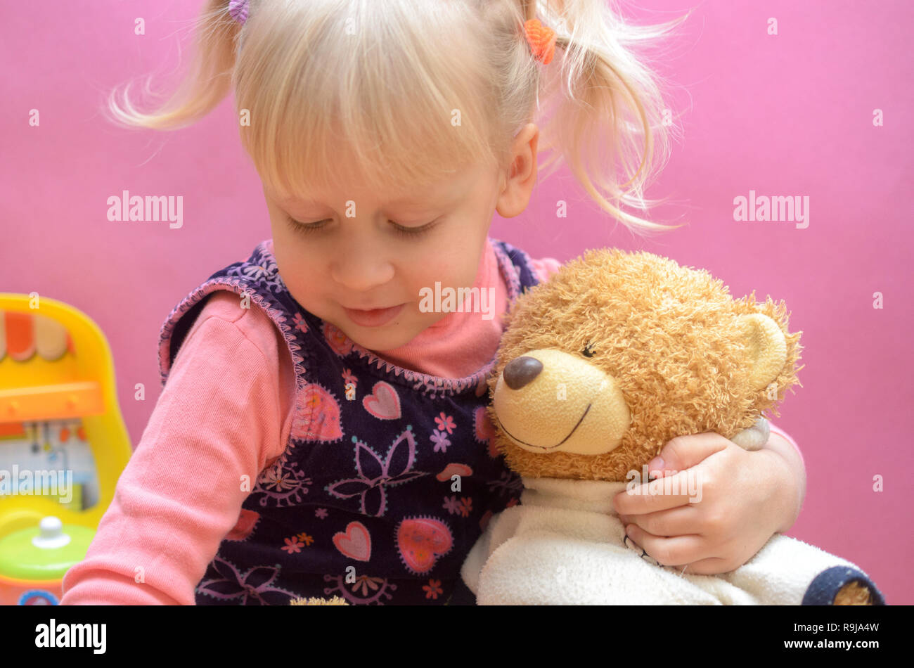 The little girl is playing with any soft toys Stock Photo - Alamy