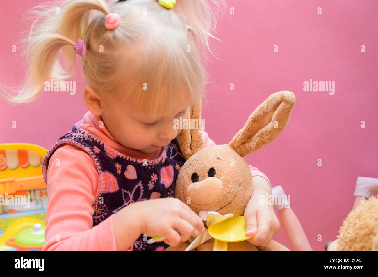 The little girl is playing with any soft toys Stock Photo - Alamy