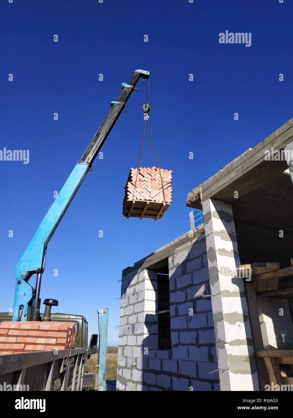 Construction crane lifting pallet building hi-res stock photography and ...