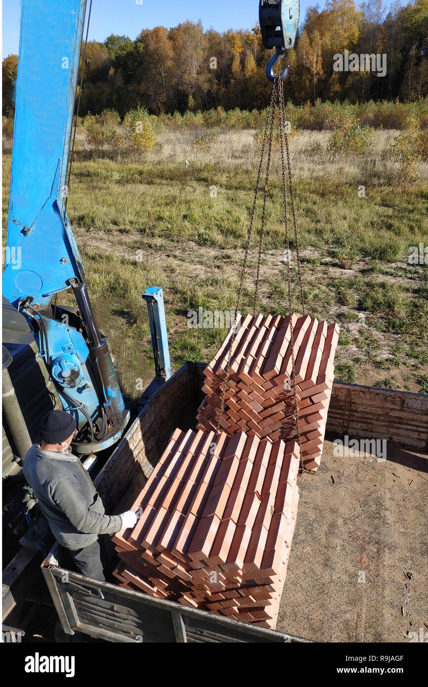 A truck crane unloads bricks for building a house 2018 Stock Photo - Alamy