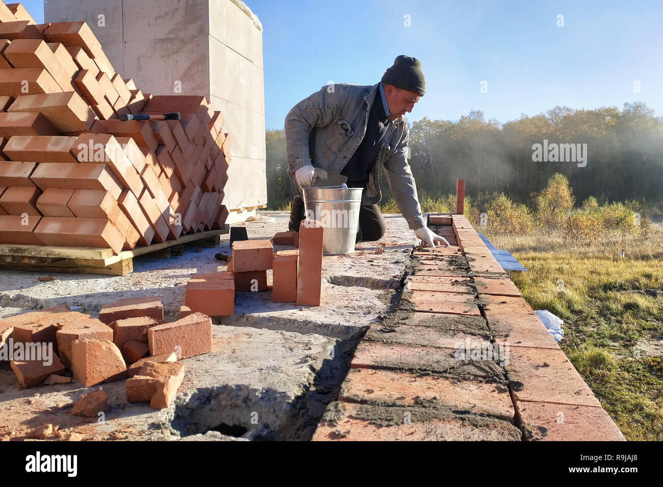 The builder uses a cement mortar for the construction of a brick wall ...