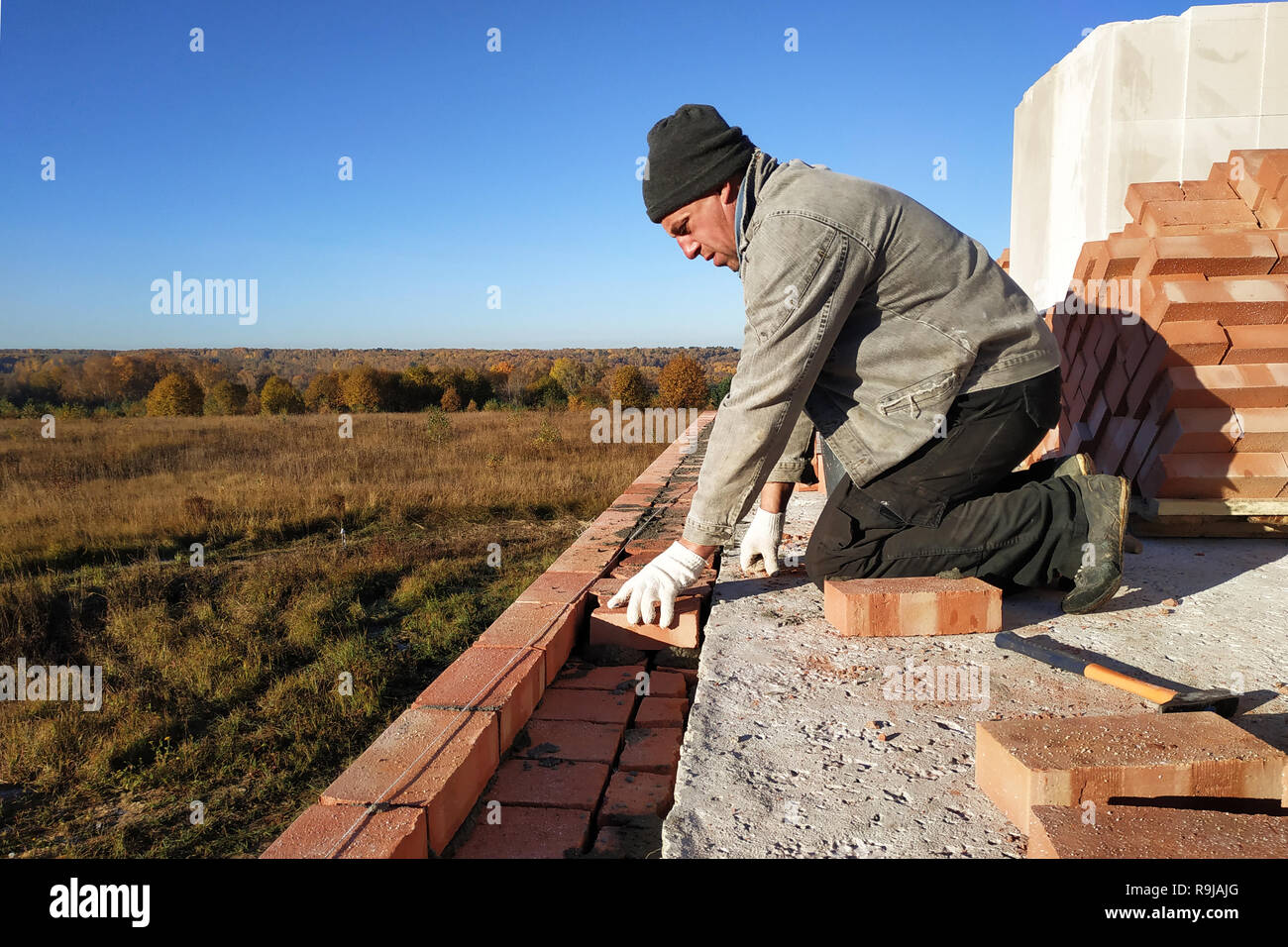 The builder uses a cement mortar for the construction of a brick wall ...