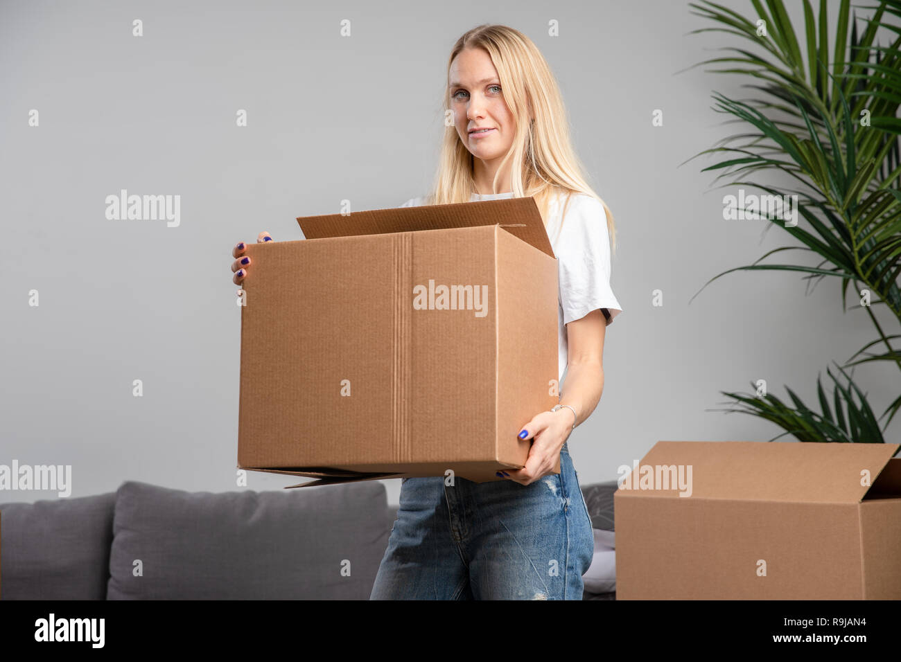 Image of woman with cardboard box in hands standing Stock Photo - Alamy