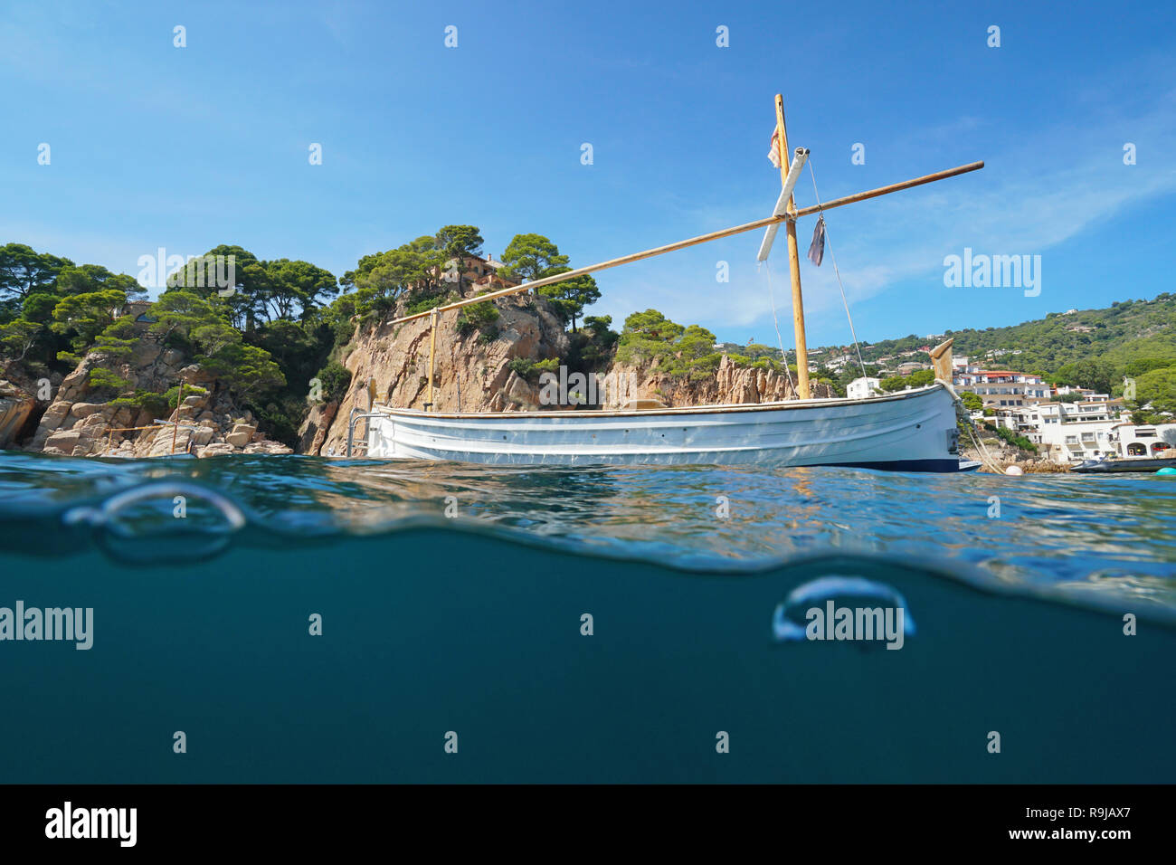 Spain typical Mediterranean boat moored in front of rocky coastline at ...