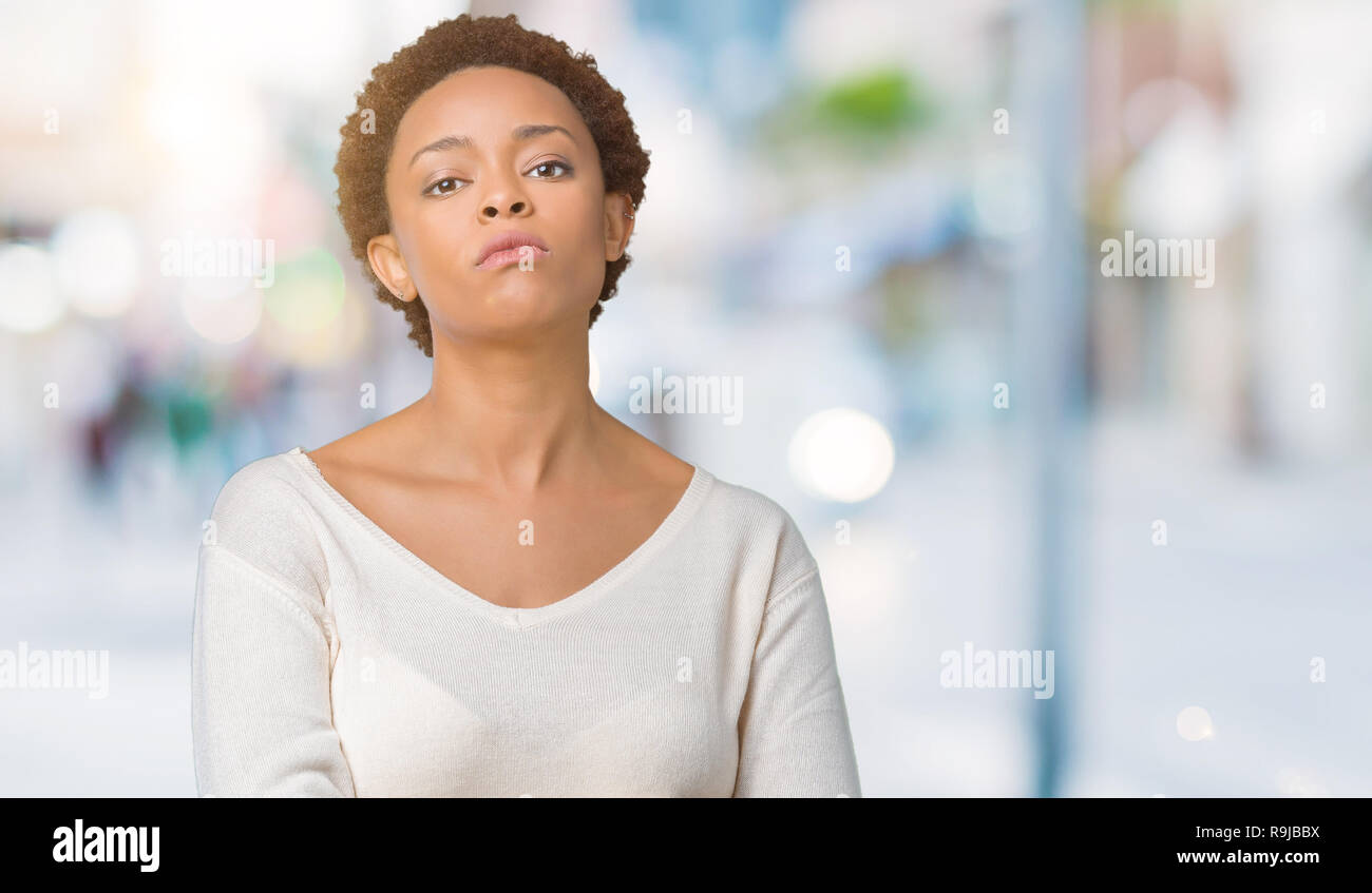 Young african american woman over isolated background skeptic and ...