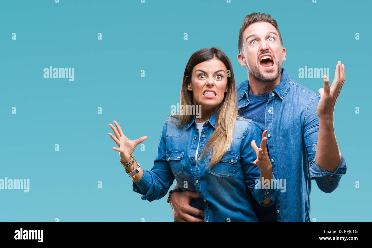 Young couple in love over isolated background crazy and mad shouting ...