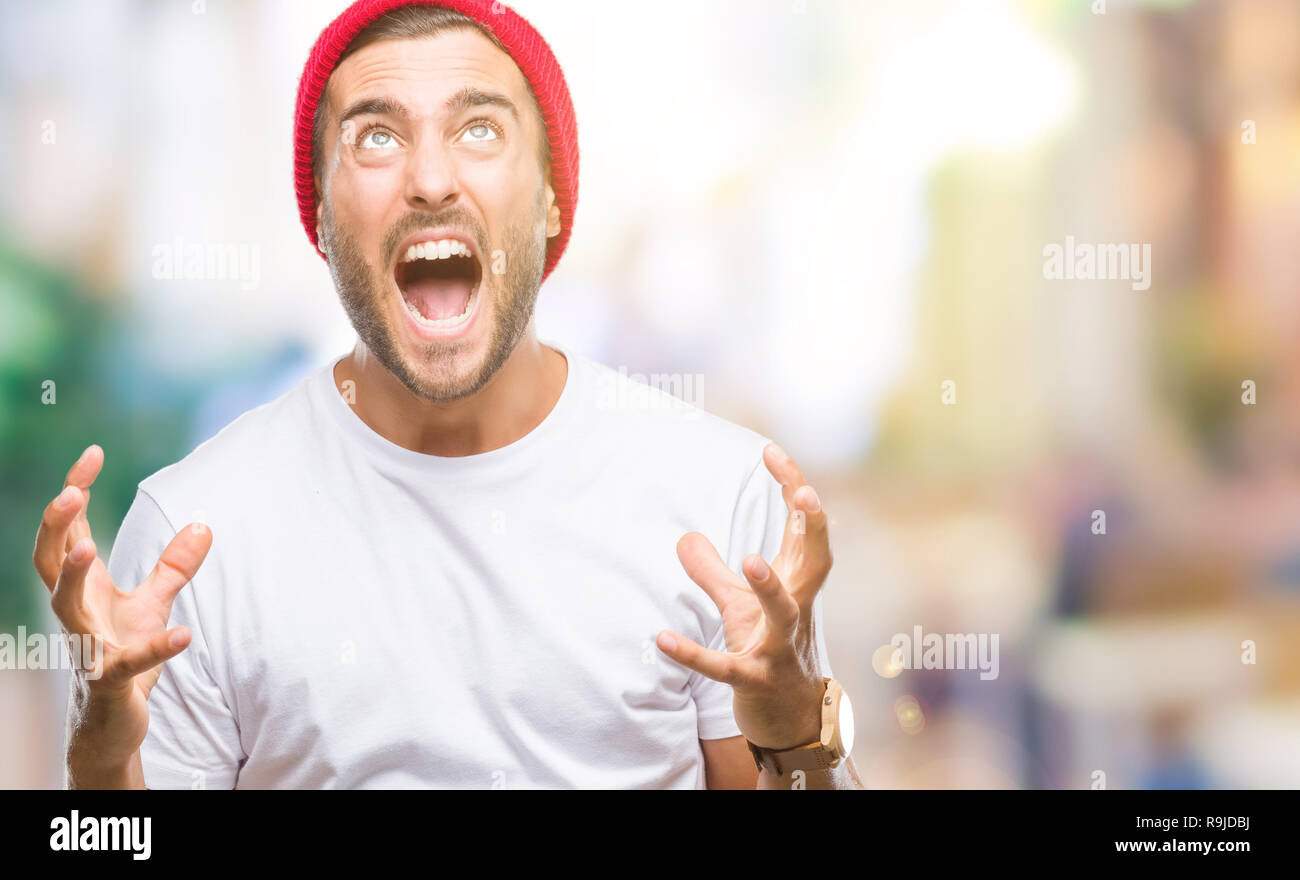 Young handsome man over isolated background crazy and mad shouting and ...