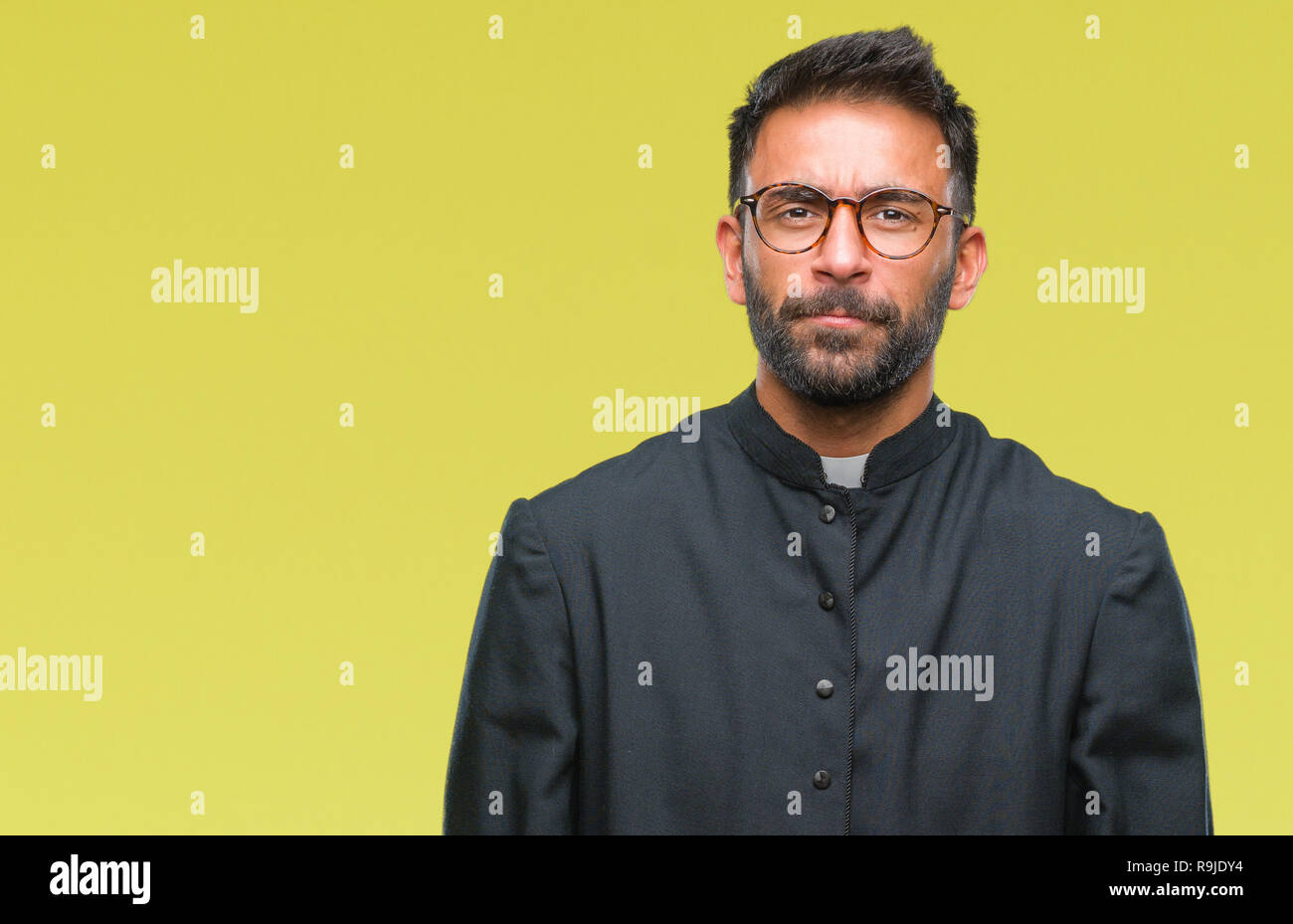 Adult hispanic catholic priest man over isolated background depressed ...