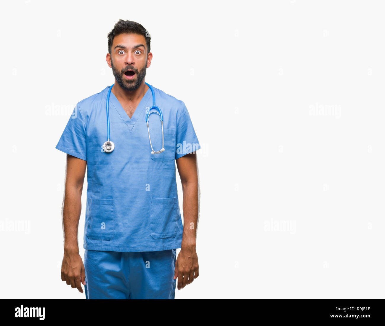 Adult hispanic doctor or surgeon man over isolated background afraid ...