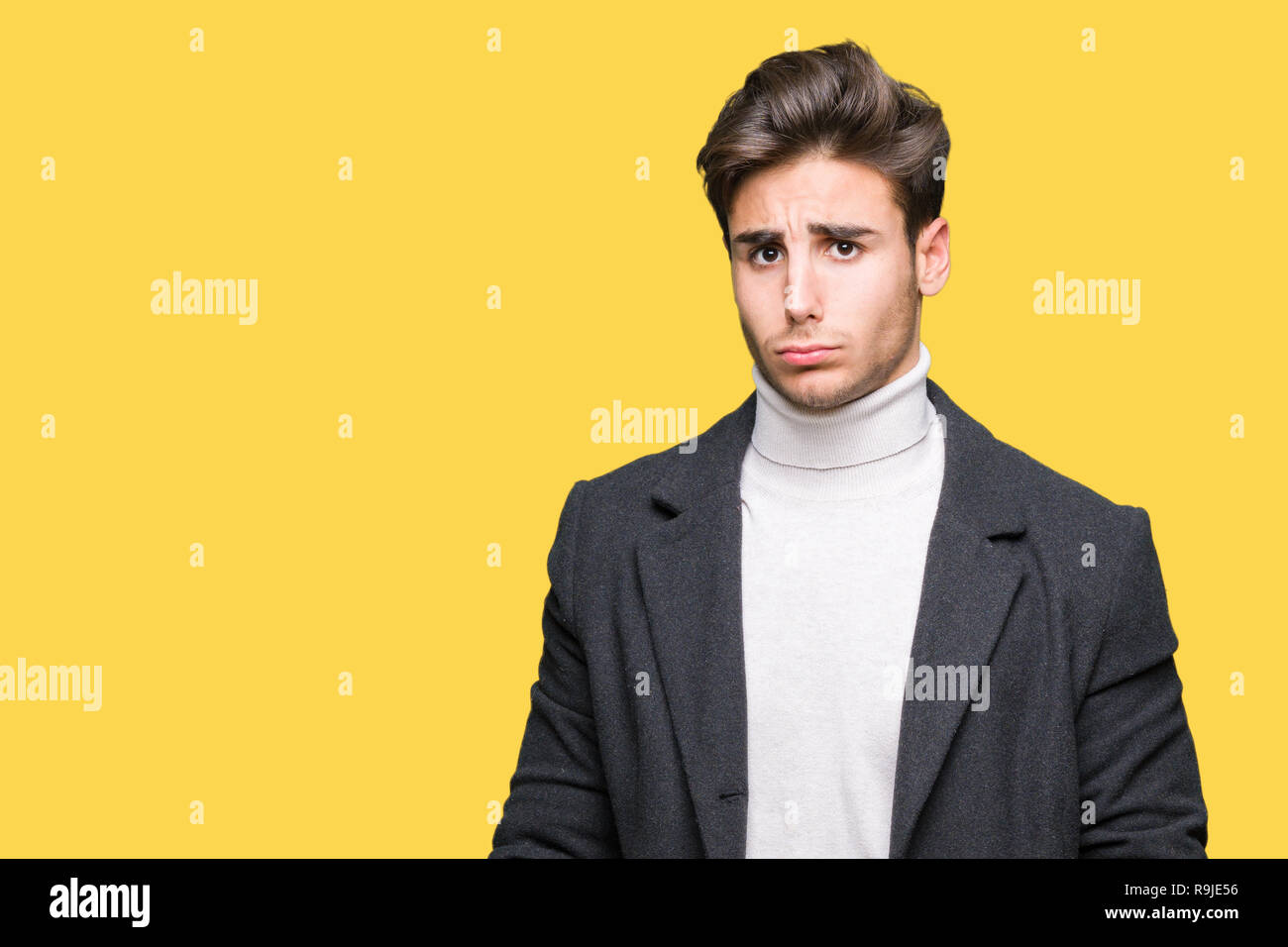 Young elegant man wearing winter coat over isolated background ...