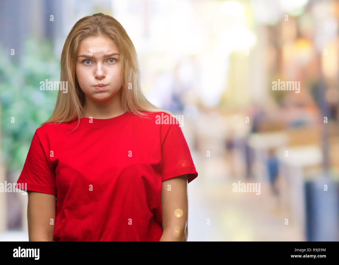 Young caucasian woman over isolated background puffing cheeks with ...