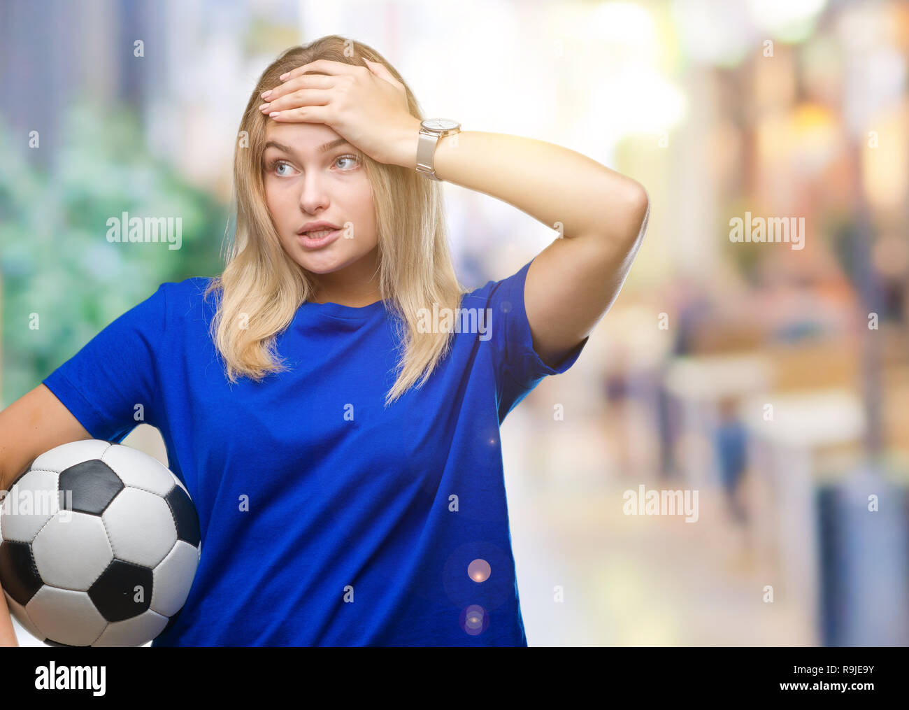 Young caucasian woman holding soccer ball over isolated background ...