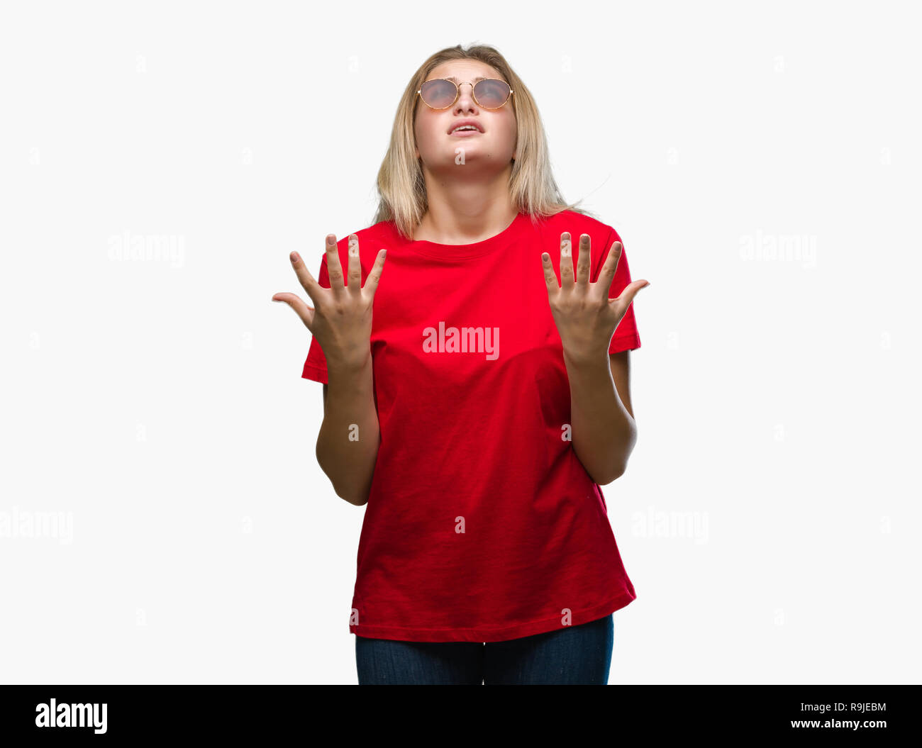 Young caucasian woman wearing sunglasses over isolated background crazy ...