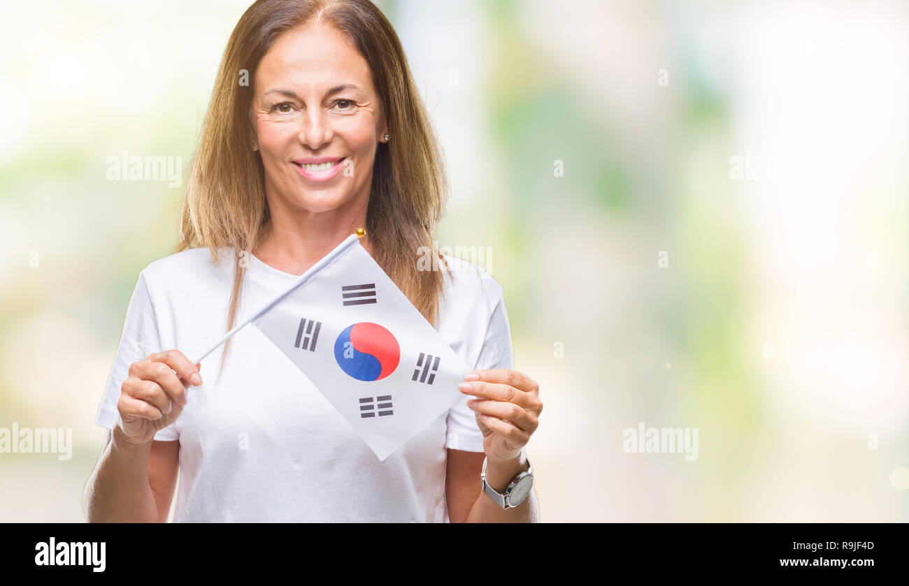 Middle age hispanic woman holding flag of South Korea over isolated ...