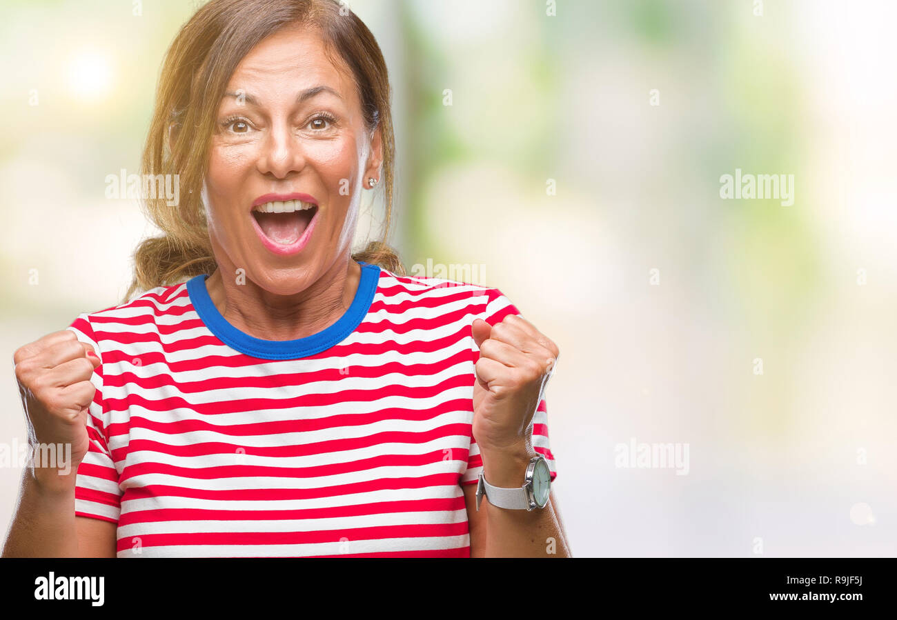 Middle age senior hispanic woman over isolated background celebrating ...