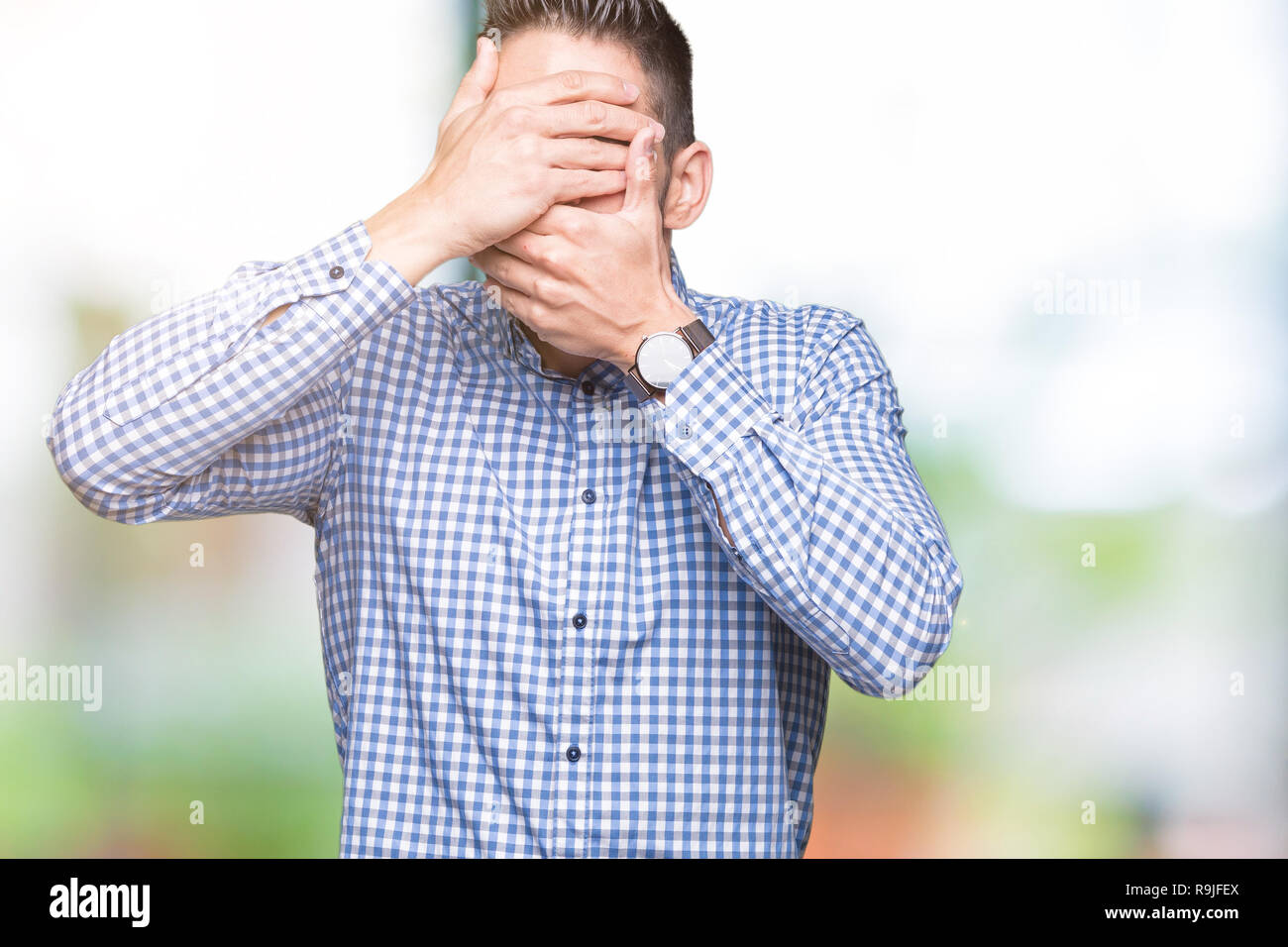 Young handsome man over isolated background Covering eyes and mouth with hands, surprised and ...