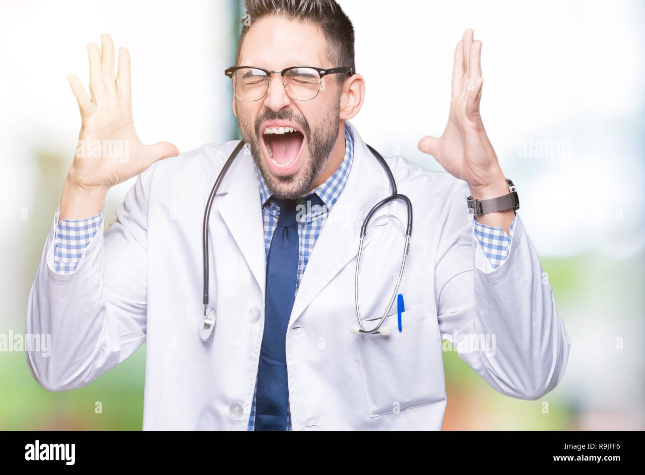 Handsome young doctor man over isolated background celebrating mad and ...