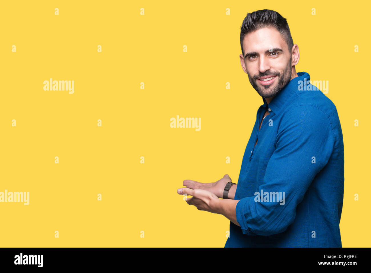 Young handsome man over isolated background Inviting to enter smiling ...