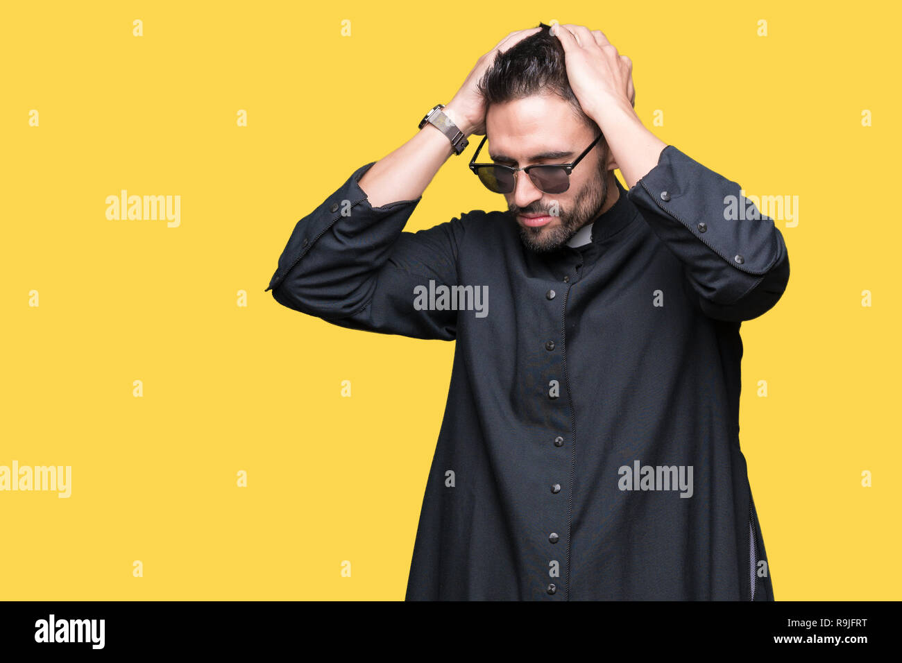 Young Christian priest wearing sunglasses over isolated background ...