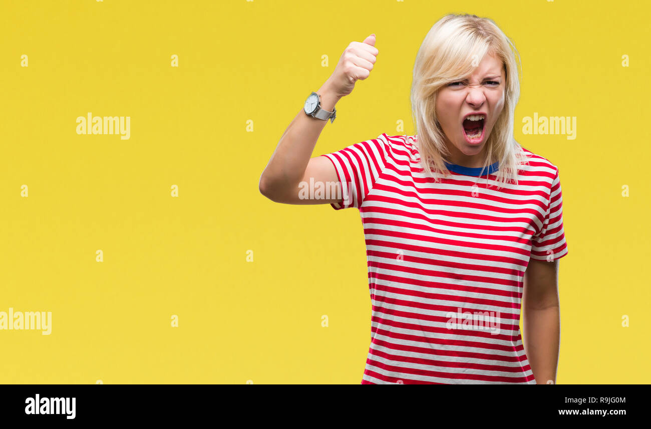 Young beautiful blonde woman over isolated background angry and mad ...