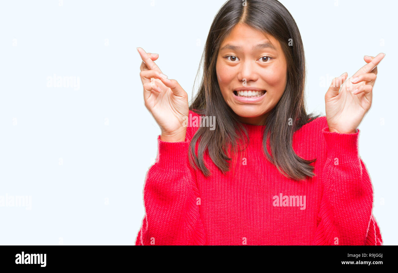 Young asian woman wearing winter sweater over isolated background ...