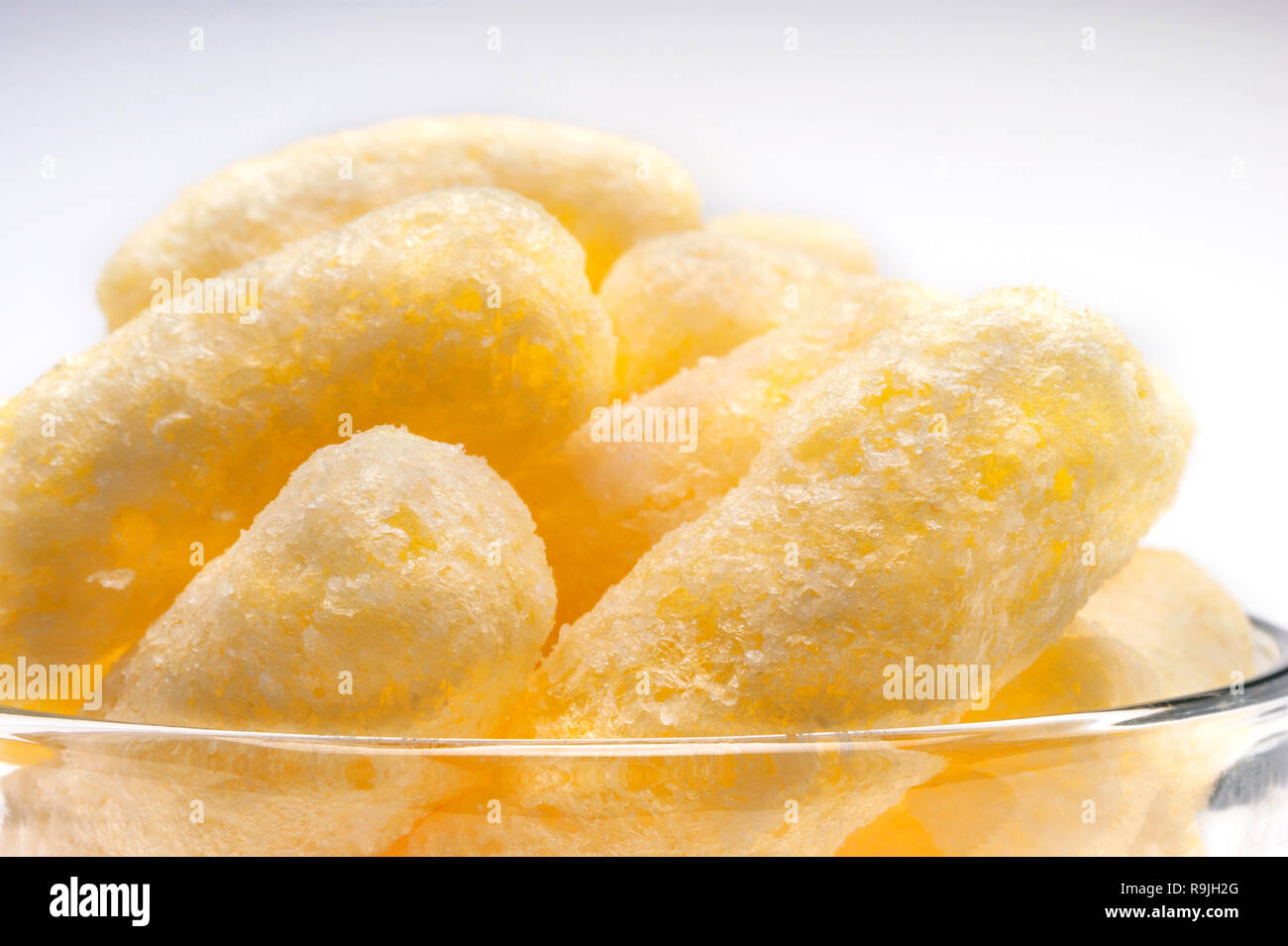 Yellow Corn Puffs in a Glass Bowl. Crunchy Flavored Puffed Snacks ...