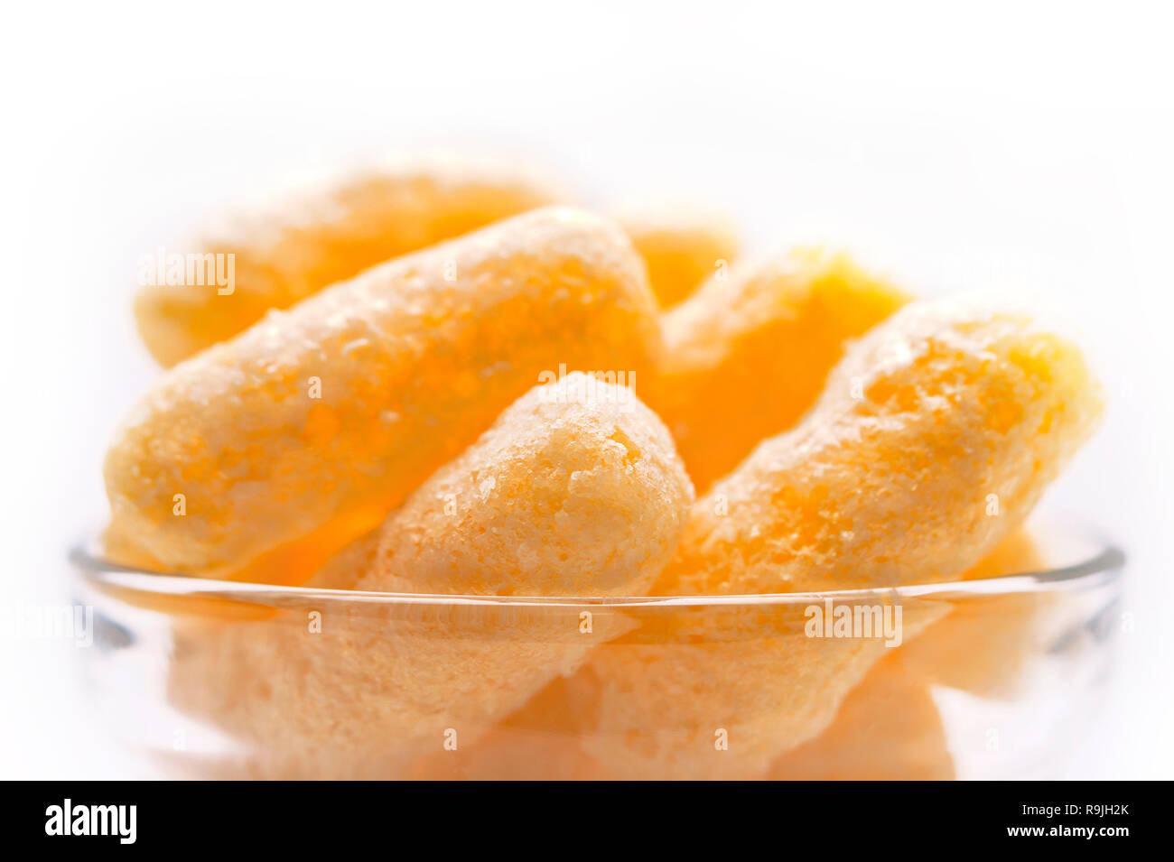 Yellow Corn Puffs in a Glass Bowl. Crunchy Flavored Puffed Snacks ...