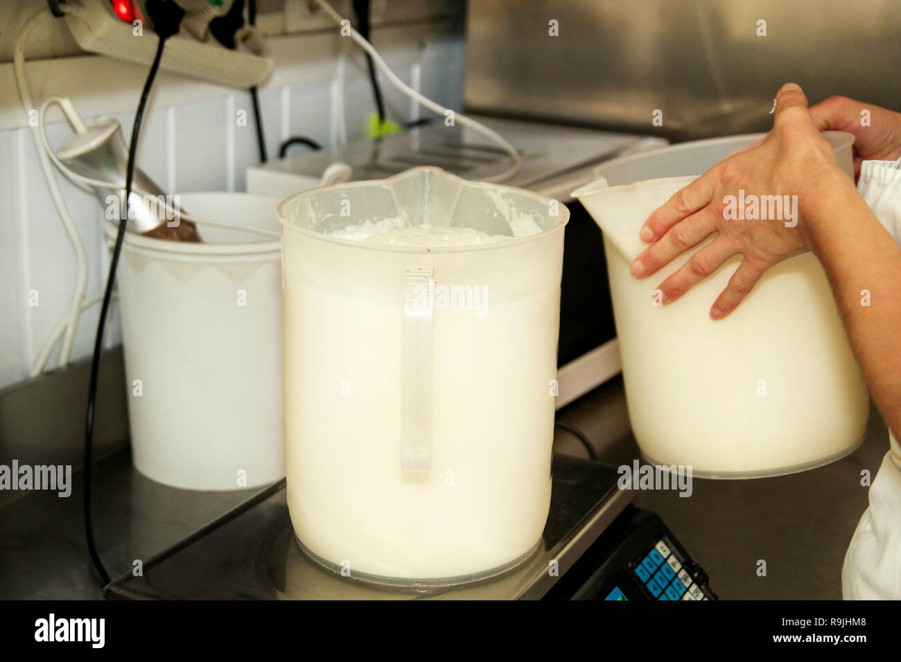 Ice cream ingredients mix together with blender. Female chef is mixing ...