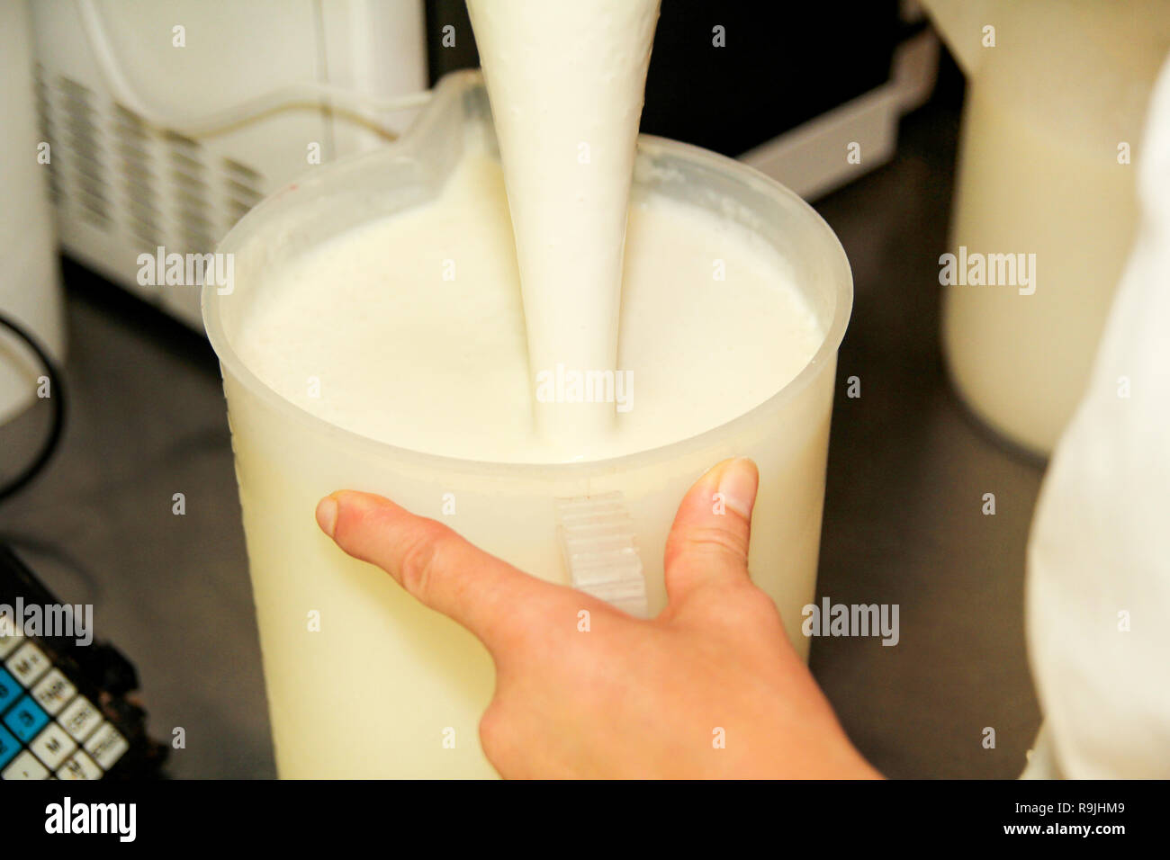 Ice cream ingredients mix together with blender. Female chef is mixing ...