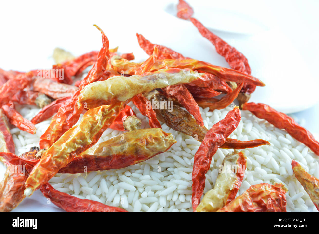 pile of rice and dried chilli on white background Stock Photo - Alamy