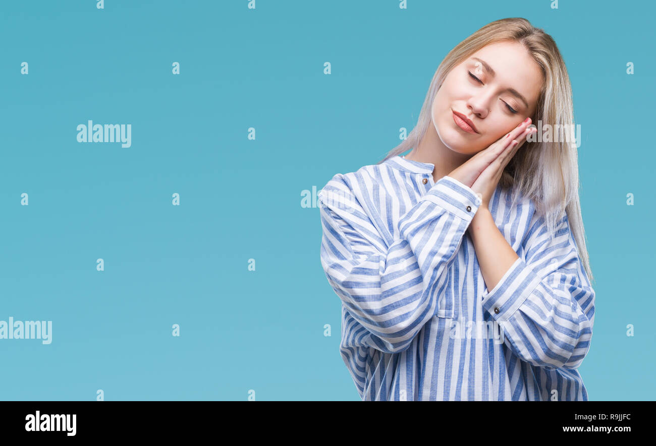 Young blonde woman over isolated background sleeping tired dreaming and ...