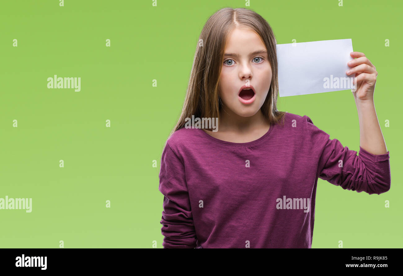 Young beautiful girl holding blank paper card over isolated background ...
