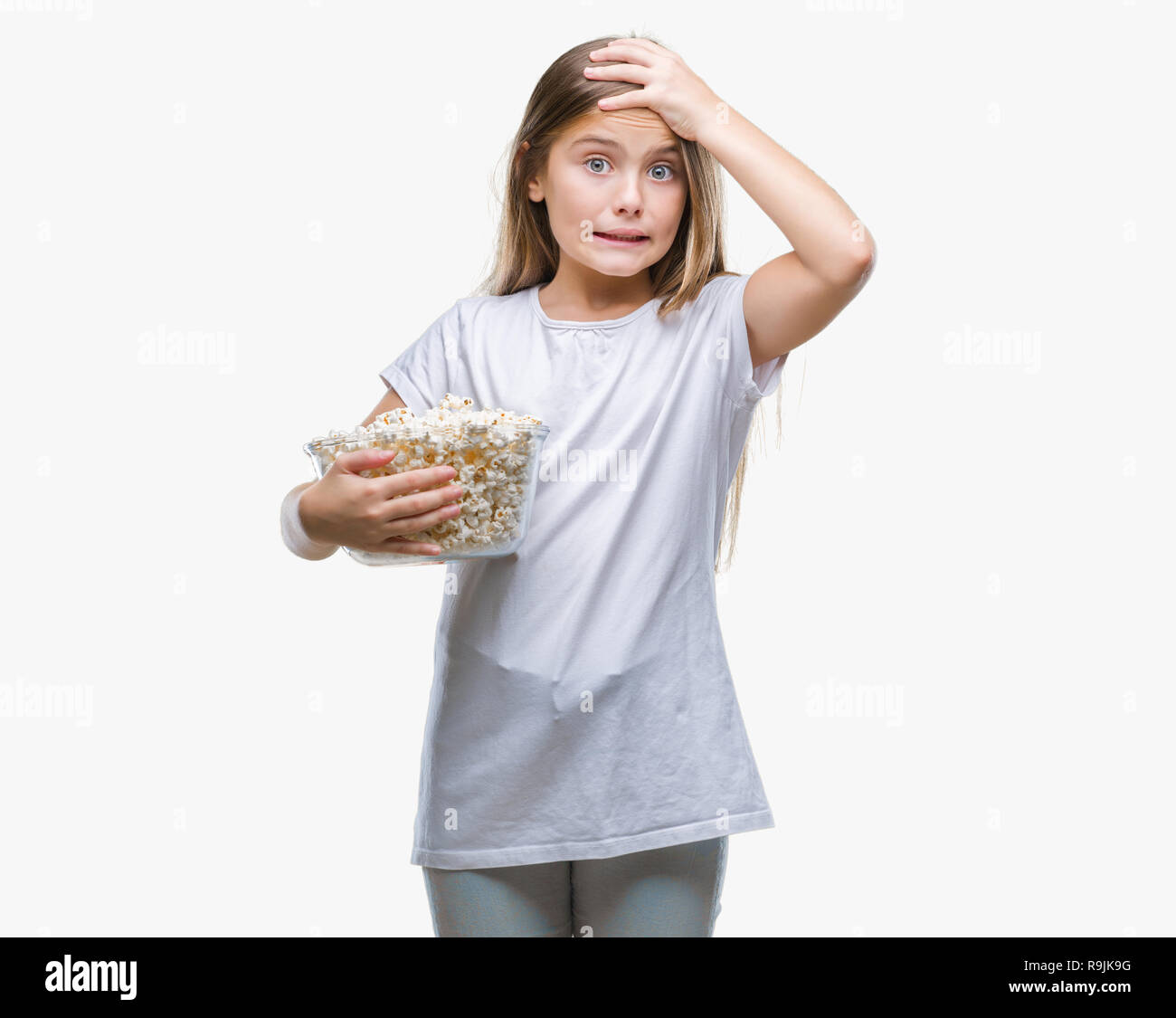 Young beautiful girl eating popcorn snack isolated background stressed ...