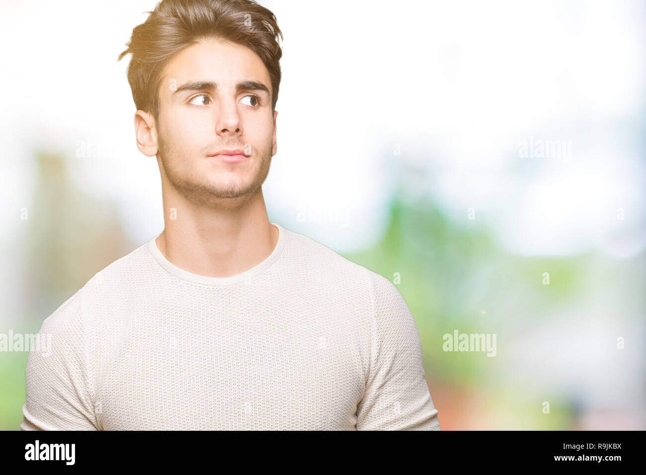 Young handsome man over isolated background smiling looking side and ...
