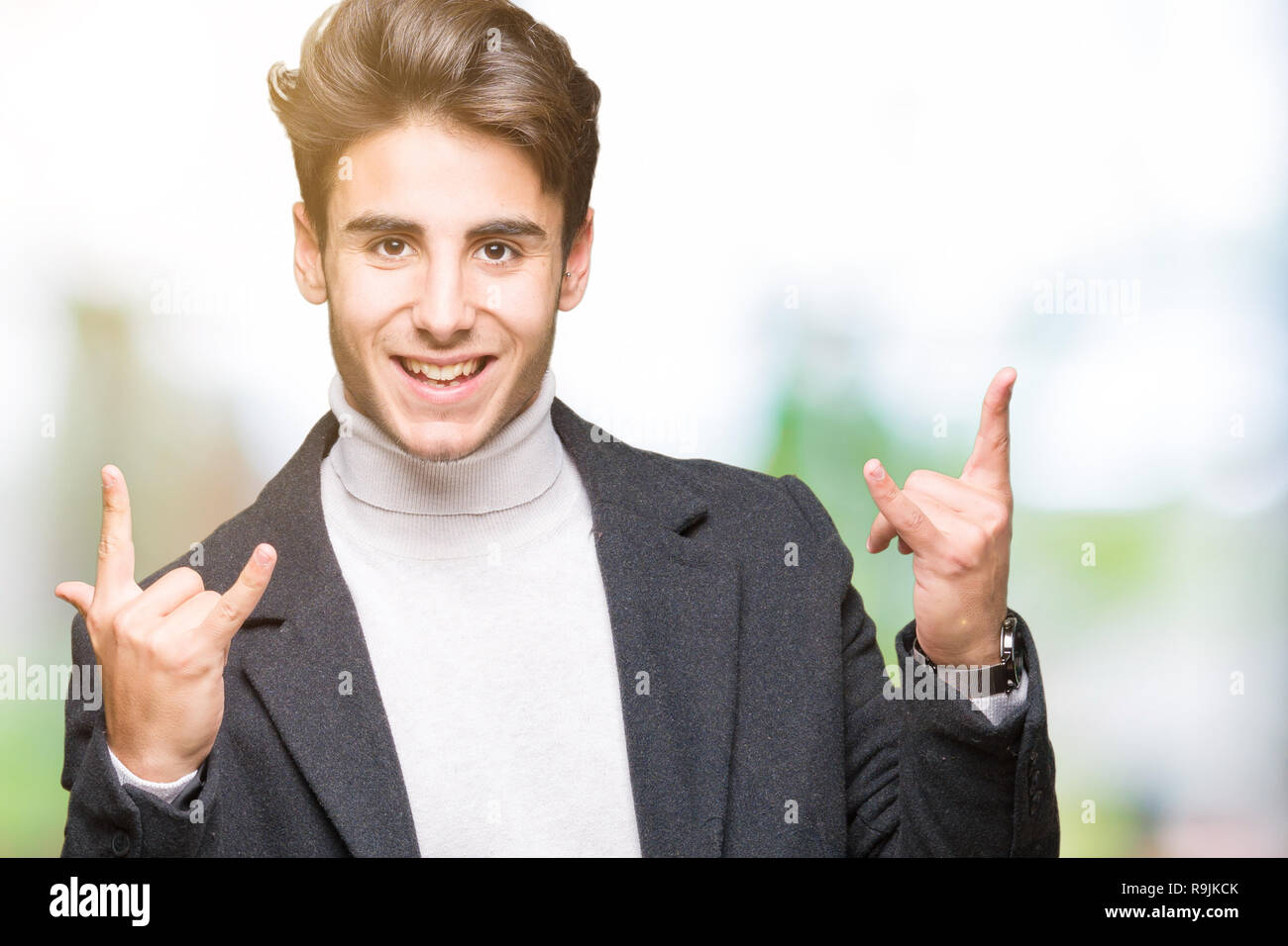 Young elegant man wearing winter coat over isolated background shouting ...