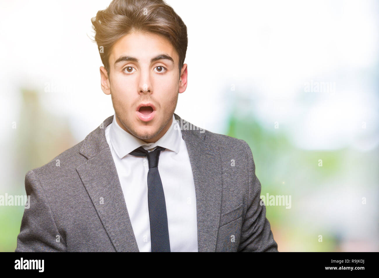 Young business man wearing suit and tie over isolated background afraid ...