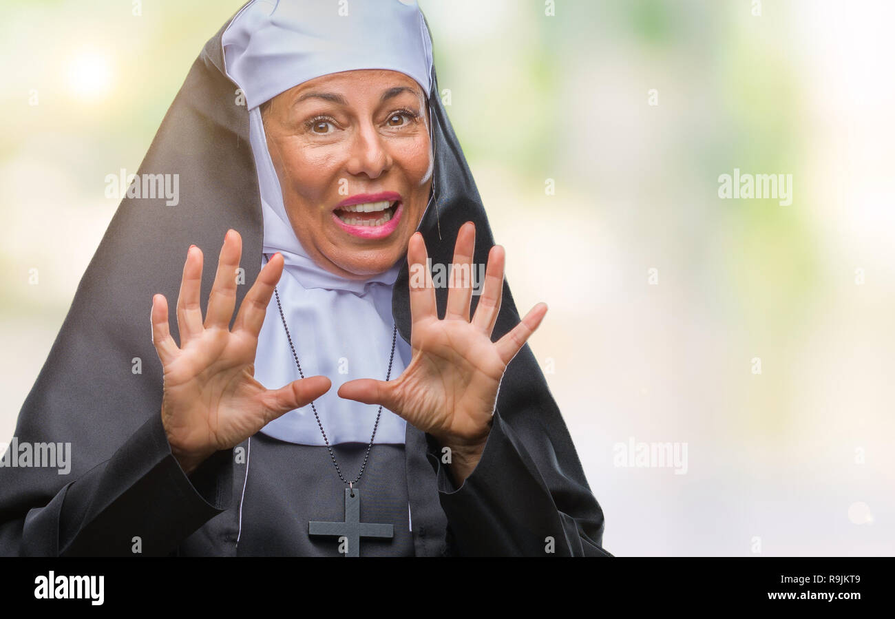 Middle age senior christian catholic nun woman over isolated background ...