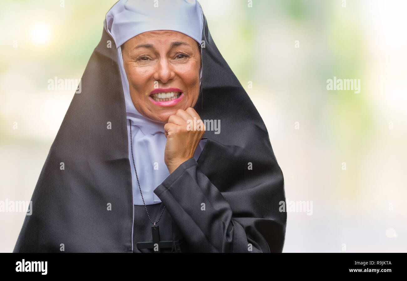 Middle age senior christian catholic nun woman over isolated background ...