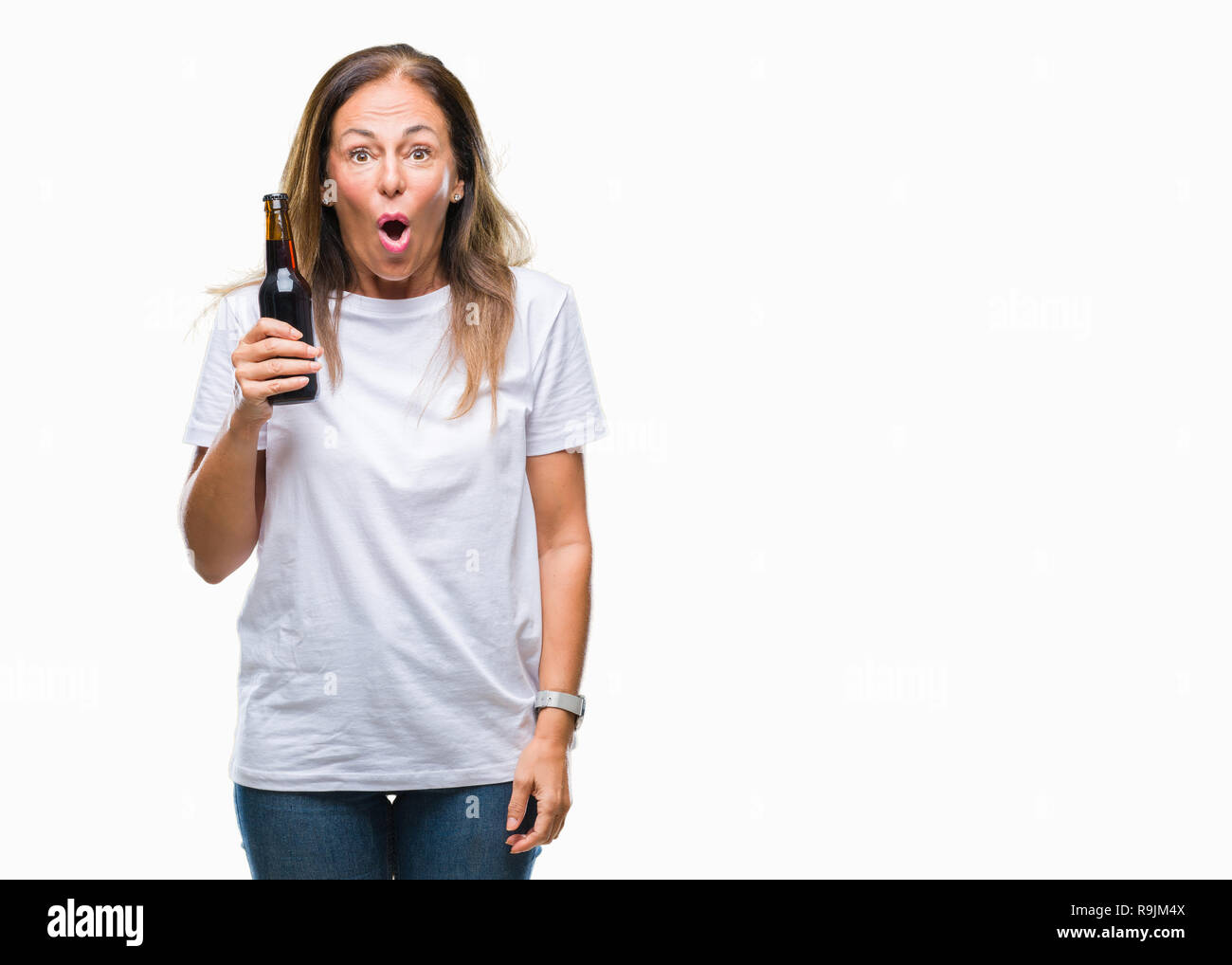 Middle age hispanic woman drinking beer over isolated background scared ...