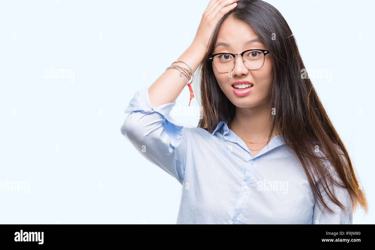 Young asian business woman wearing glasses over isolated background ...