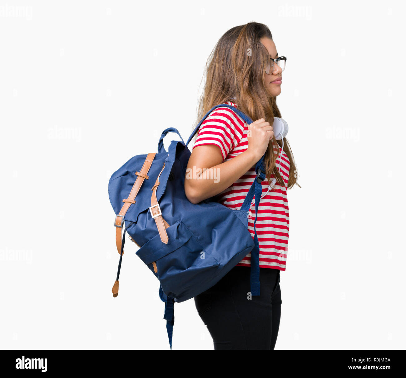 Young beautiful brunette student woman wearing headphones and backpack ...