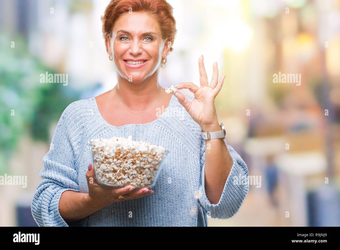 Atrractive Senior Caucasian Redhead Woman Eating Popcorn Over Isolated